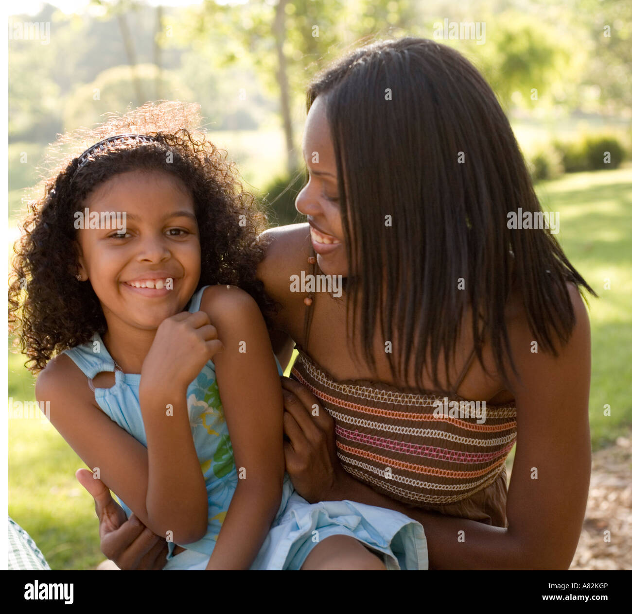 A mother and daughter sitting in a park Stock Photo - Alamy