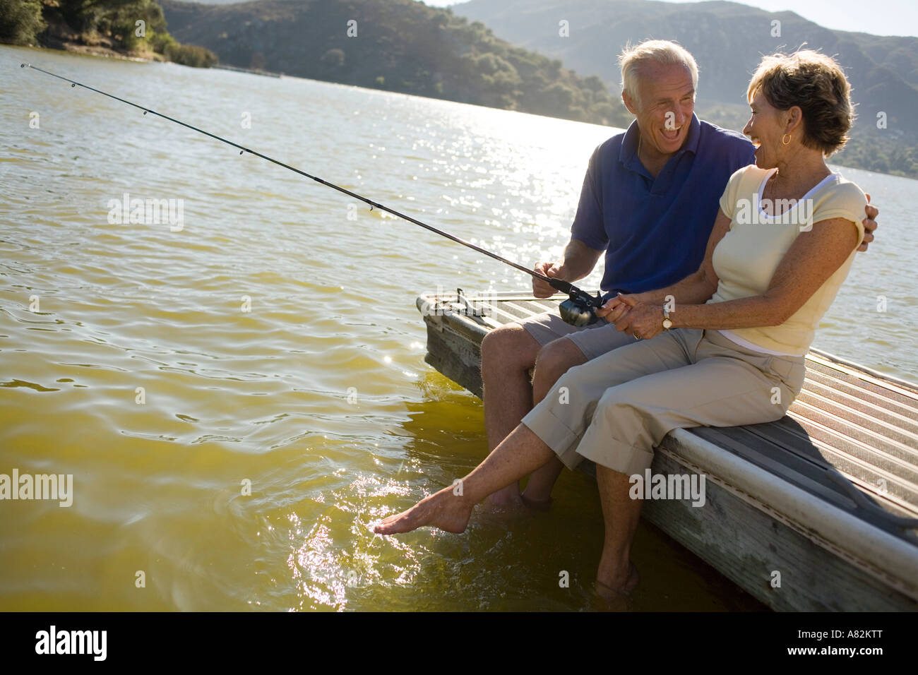 A couple fishing on a dock Stock Photo - Alamy