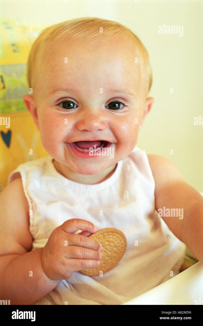 A baby eating a biscuit Stock Photo - Alamy