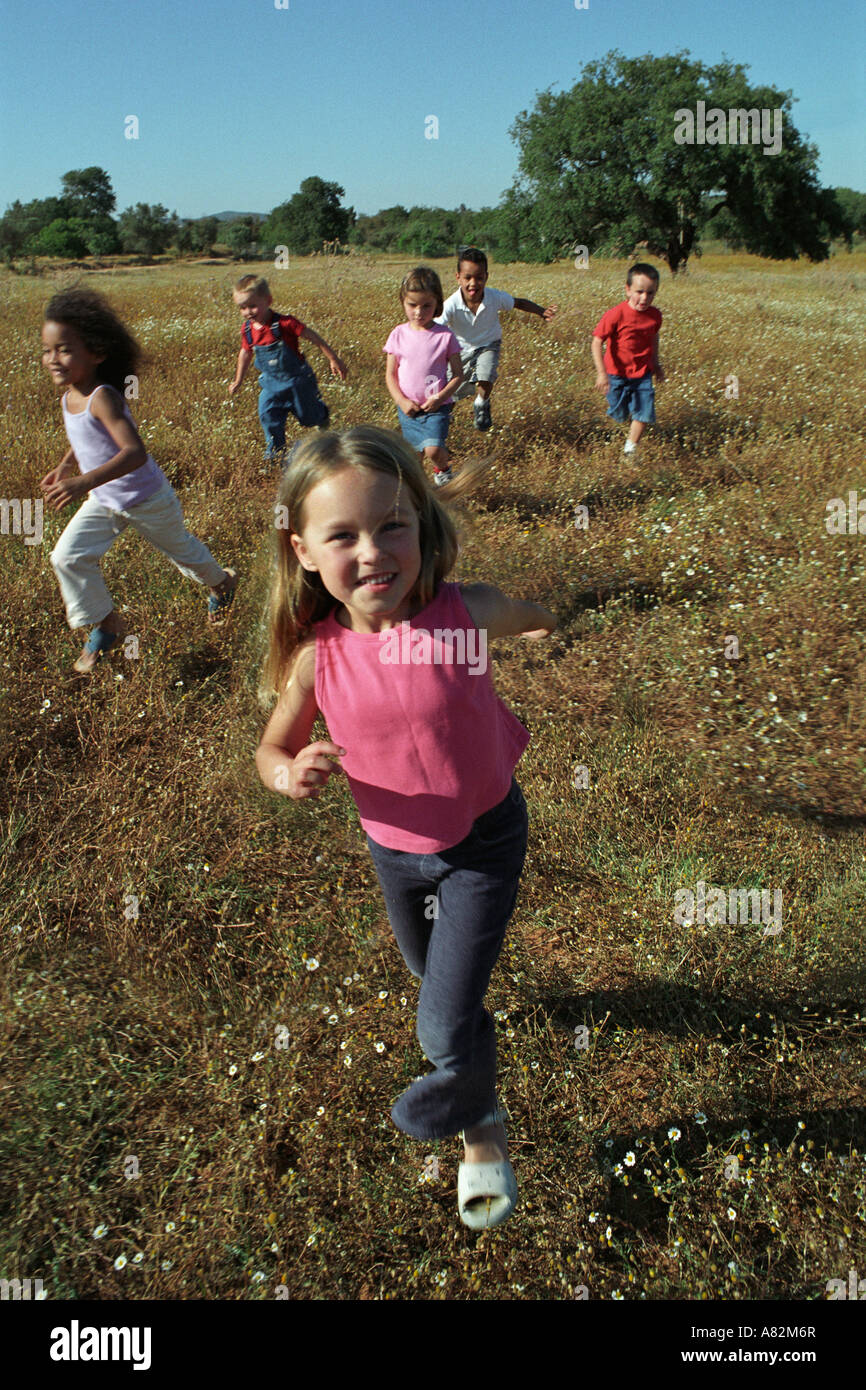Six children running in a field Stock Photo - Alamy