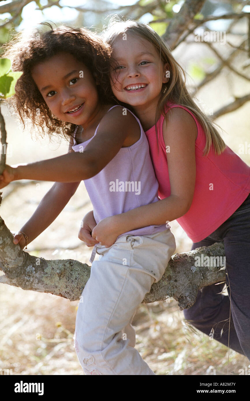 Two girls sitting in a tree Stock Photo - Alamy