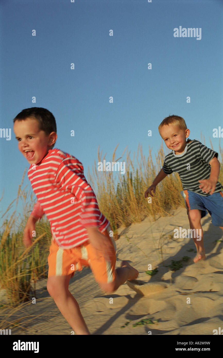 Two boys running in sand dunes Stock Photo - Alamy