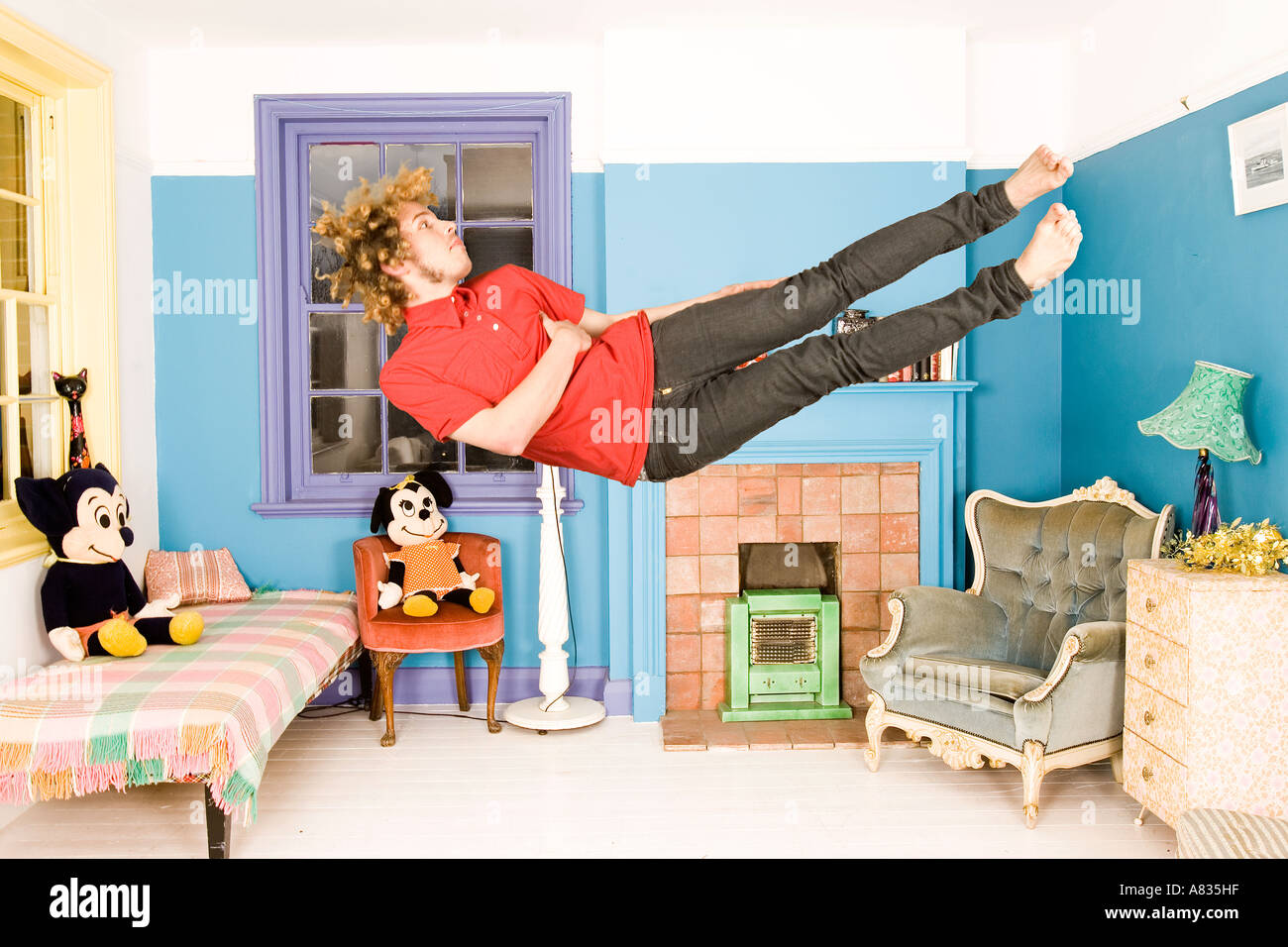 An airborne man in tight dress falling horizontally in a colourfully ...