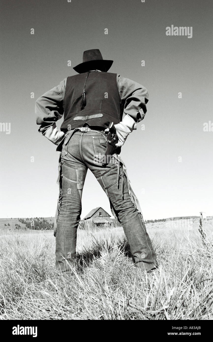 A cowboy standing out on the ranch in front of a cabin Stock Photo - Alamy