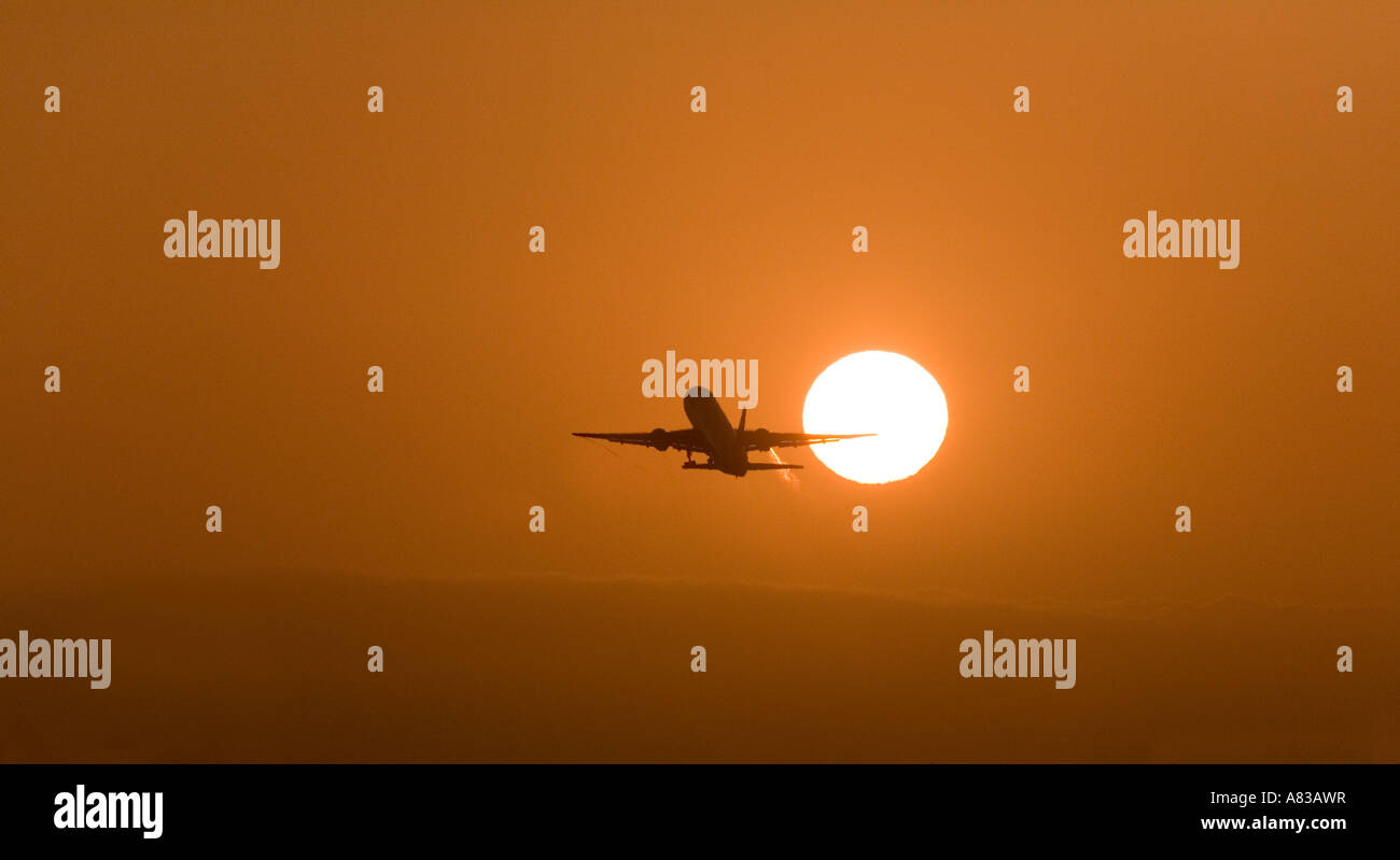 A jet takes off from Los Angeles International Airport as the sun sets ...