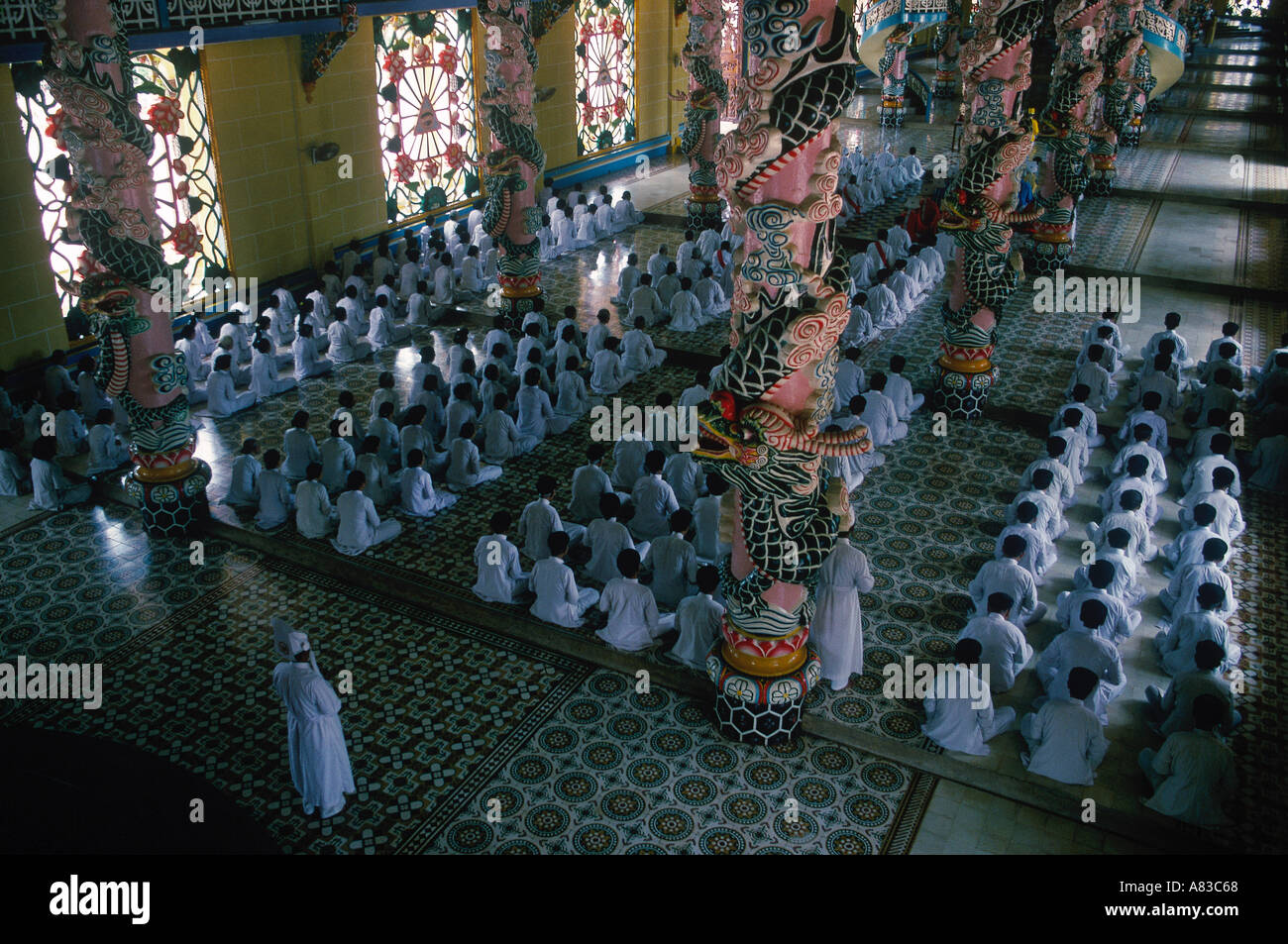 Caodaist disciples, sitting by colorful columns with dragons, Cao Dai ...