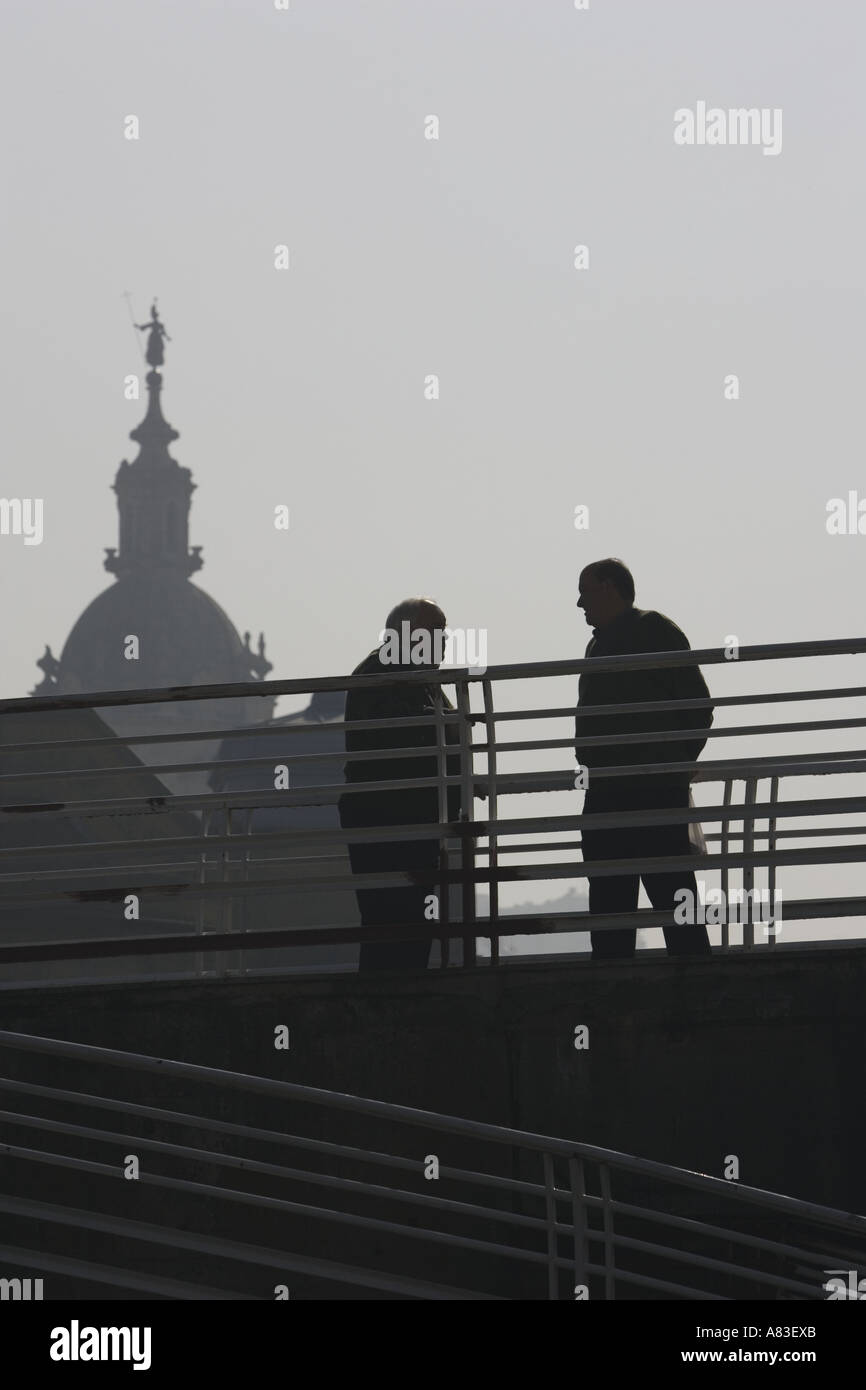 Two men standing talking on bridge over the River Nervion Bilbao ...