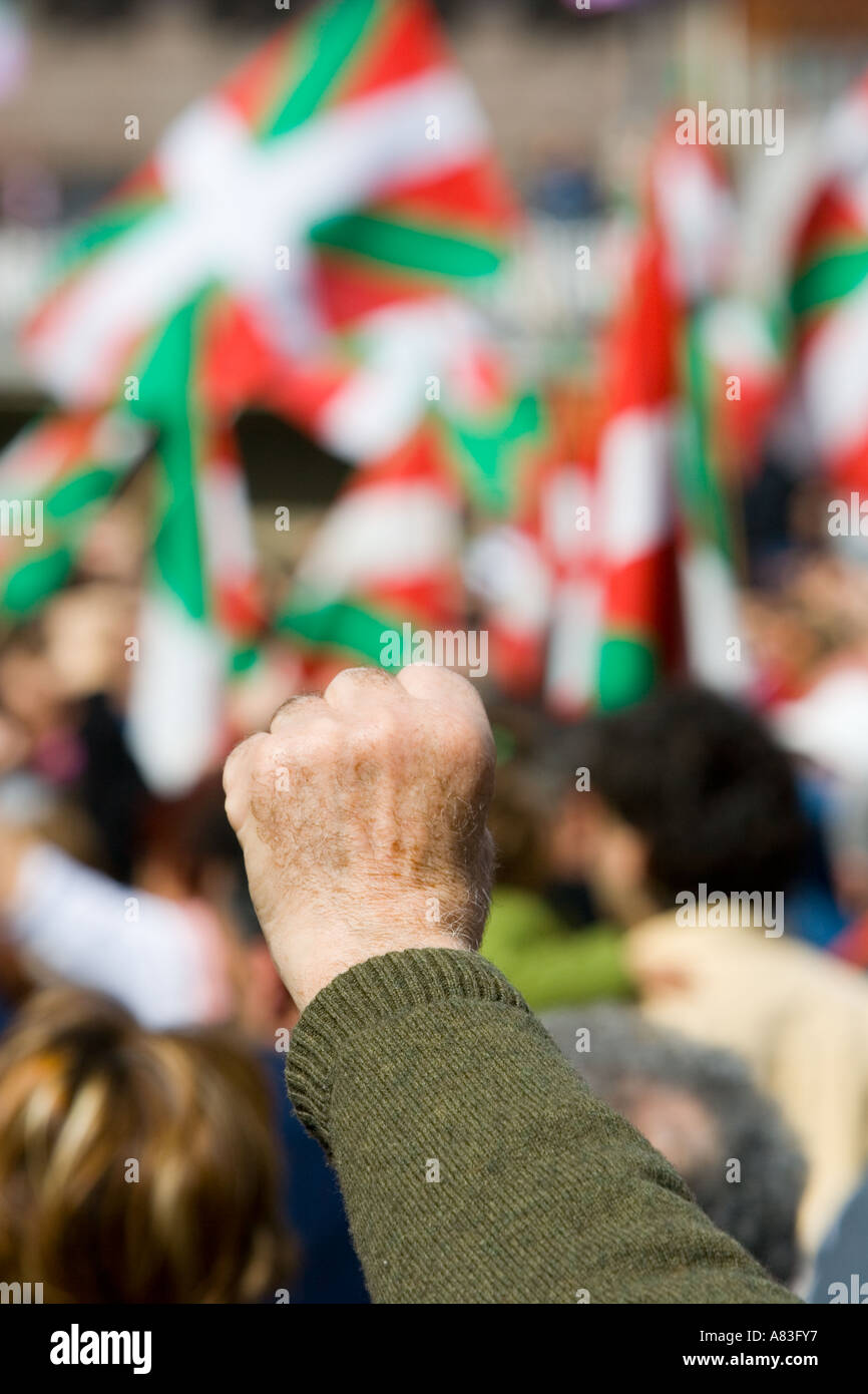 Man giving clenched fist salute, Ikurrina Basque flag in background ...