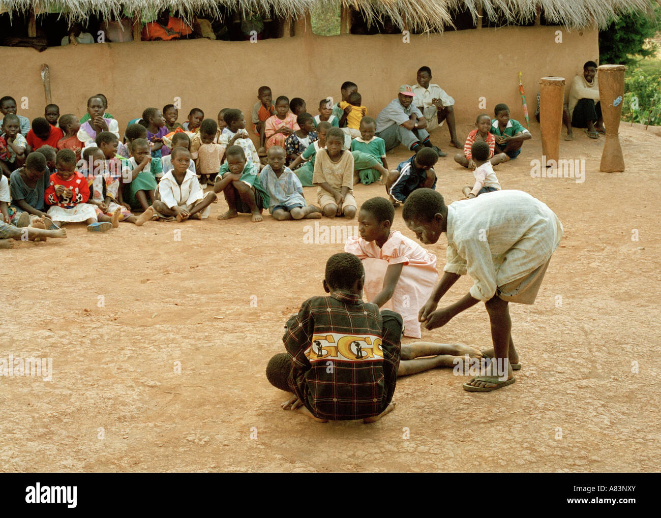 Local children performing a traditional play in front of the village ...