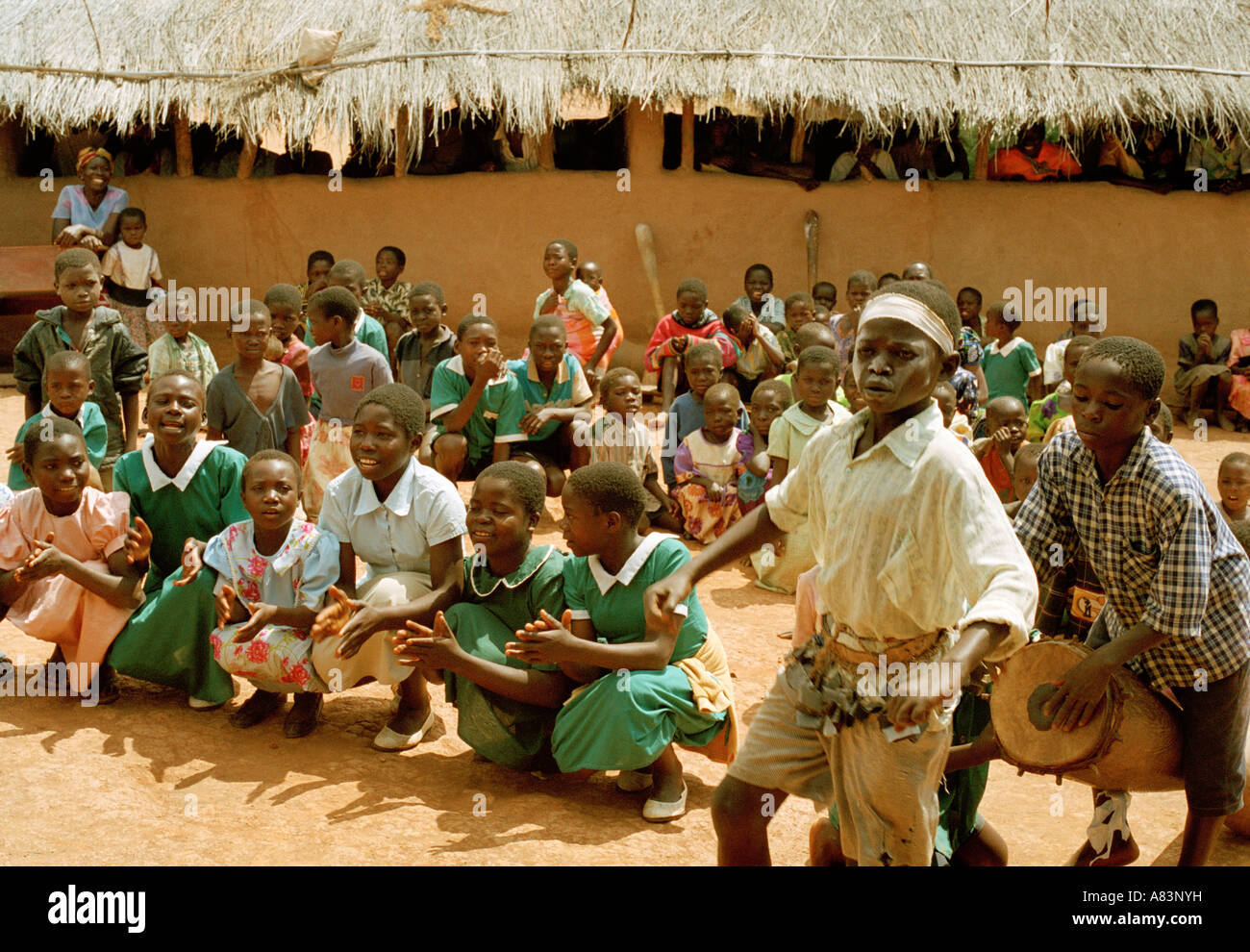 Local children performing a traditional play in front of the village ...