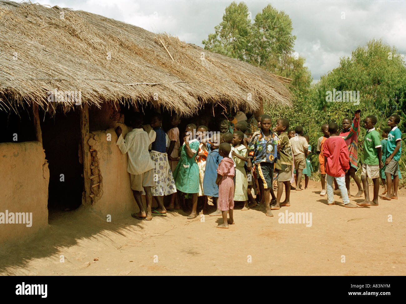 Group of village children gathering around a school hut in Malawi, East ...