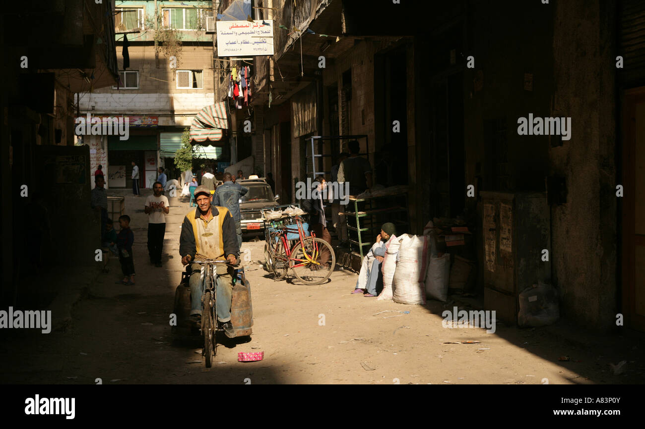 Man cycling through busy backstreet with traders, Cairo, Egypt, Middle ...