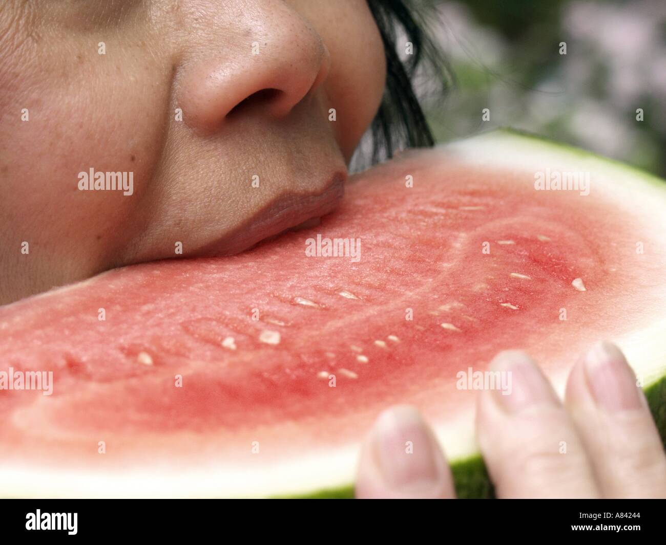 A Girl Biting Into a Slice of Watermelon Stock Photo - Alamy