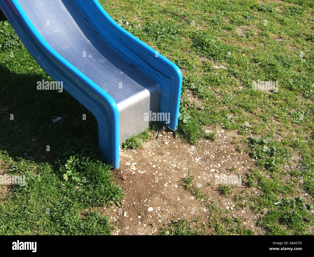 slide and ride in run down urban decay playground Stock Photo - Alamy
