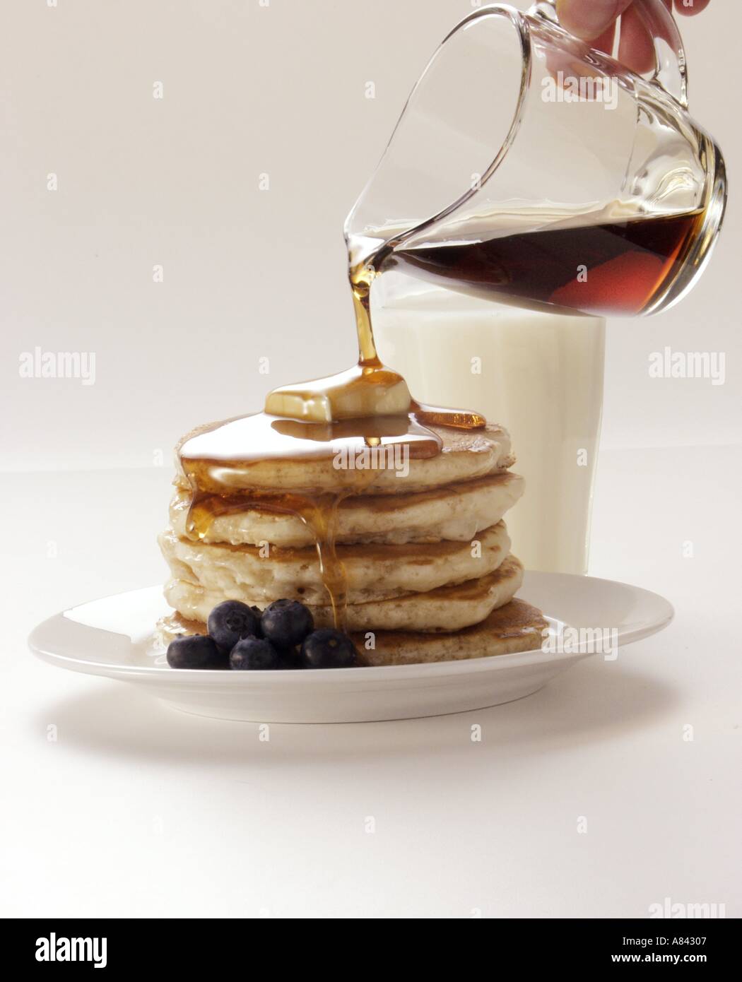 Pouring Maple Syrup Over a Stack of Pancakes Stock Photo - Alamy
