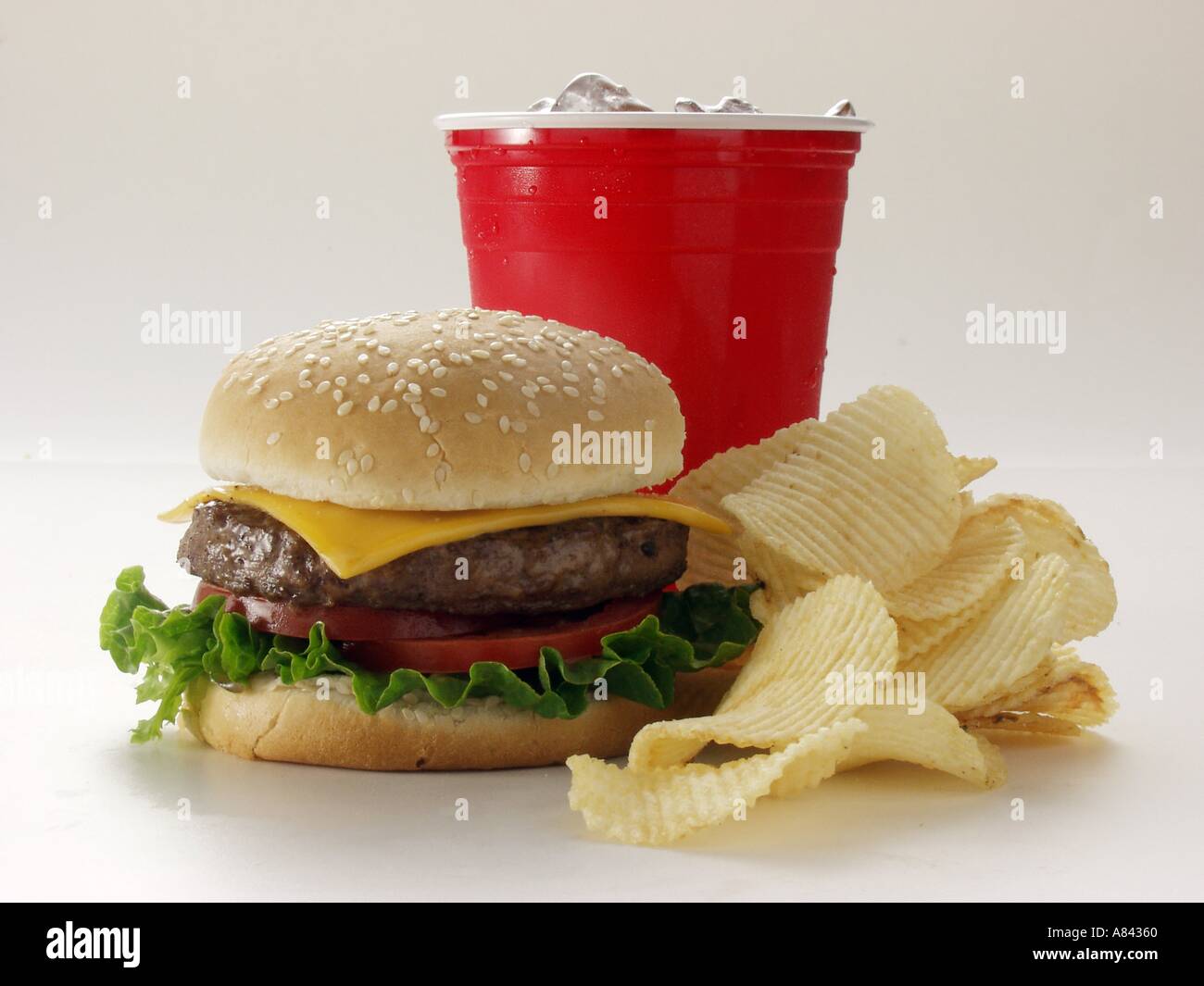 A Cheeseburger with Potato Chips and Soda Stock Photo - Alamy