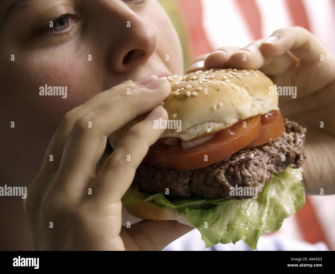 A Woman Biting into a Hamburger Stock Photo - Alamy