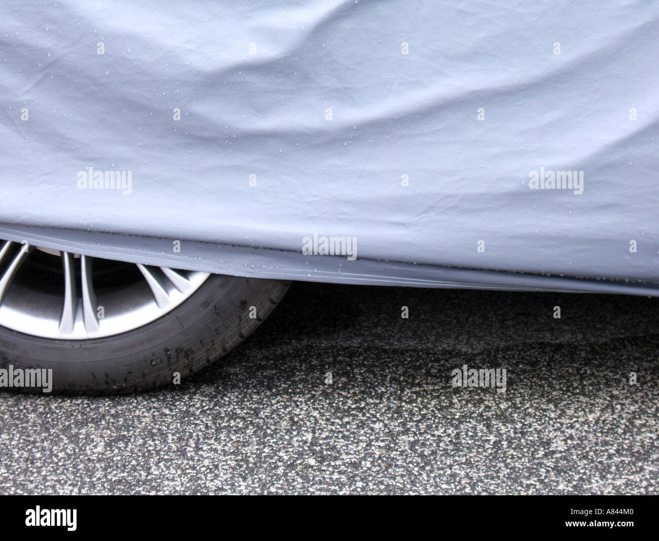 car covered with grey tarpaulin sheet Stock Photo - Alamy