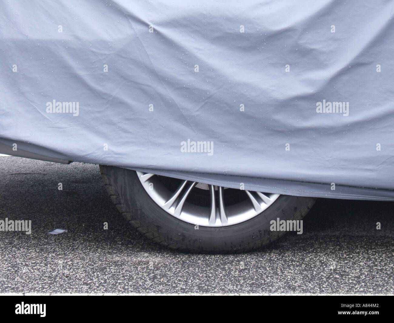 car covered with grey tarpaulin sheet Stock Photo - Alamy
