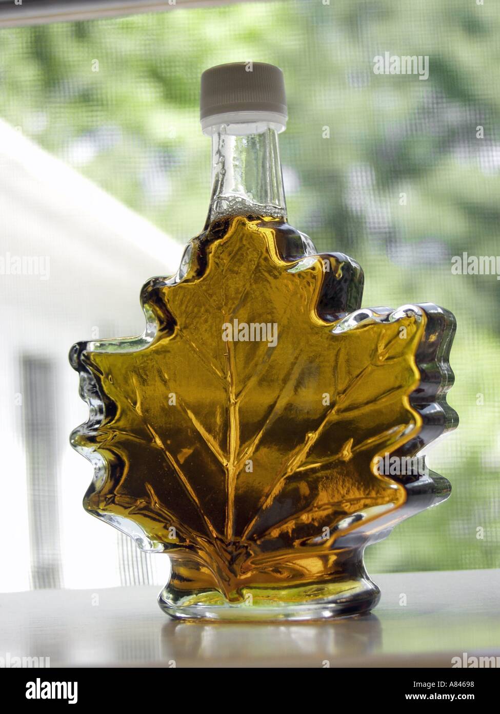 Maple Syrup in a Leaf Shaped Bottle On Window Sill Stock Photo - Alamy