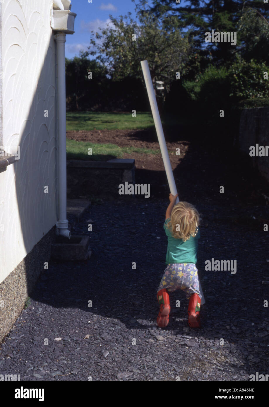 little girl carrying pole in garden Stock Photo - Alamy