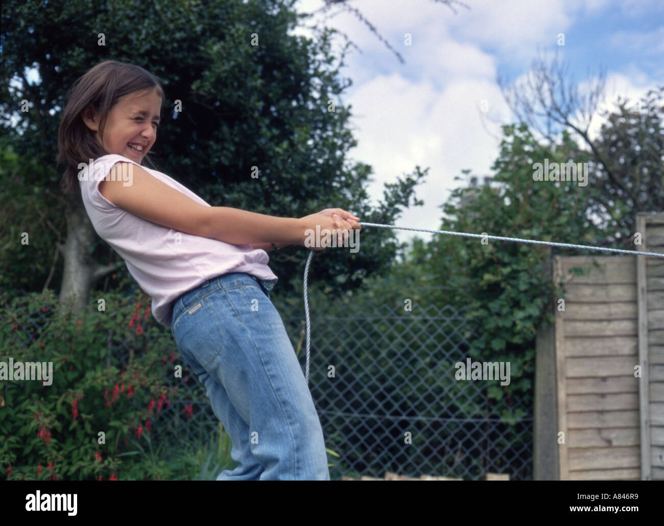 girl pulling rope in tug of war Stock Photo - Alamy