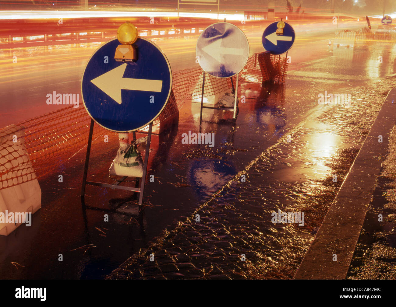 road works and arrows on busy road at night Stock Photo - Alamy