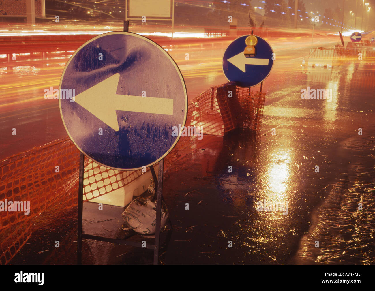 road works and arrows on busy road at night Stock Photo - Alamy