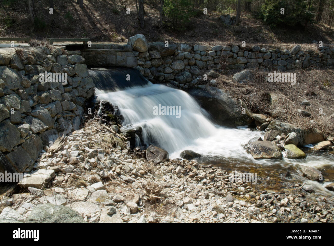 Rushing water flowing over a small dam in New Hampshire USA which is ...