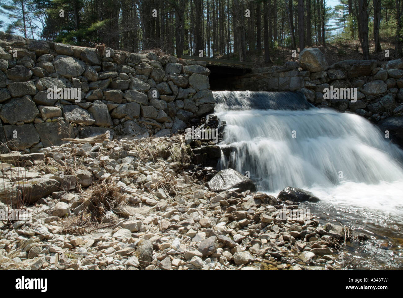 Rushing water flowing over a small dam in New Hampshire USA which is ...