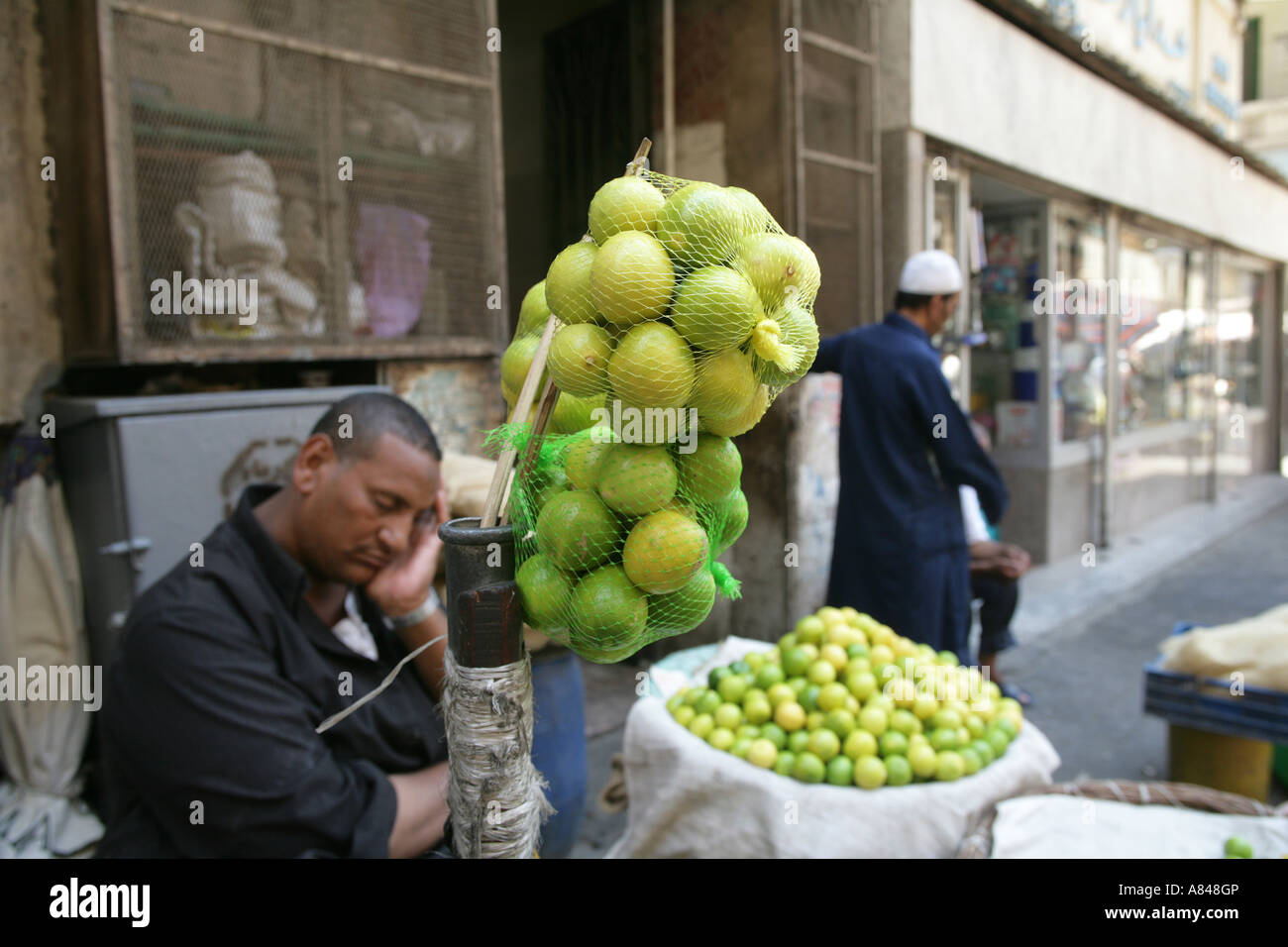 Fruit vendor on pavement by shops napping, Cairo, Egypt Stock Photo - Alamy