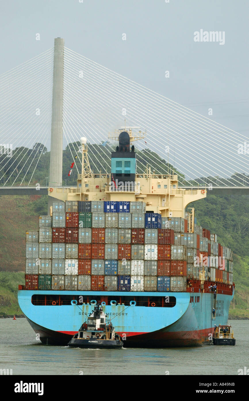 Tugboat positioning container ship in the Panama Canal under Centennial ...