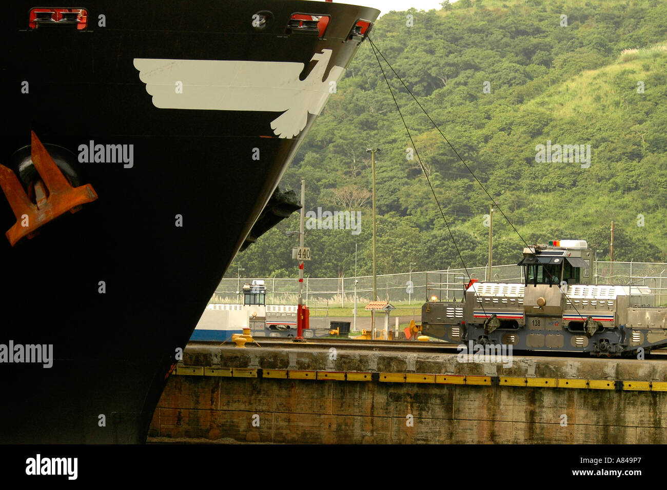 Container ship being pulled by locomotive "Mule" at Gatun Lock in the ...