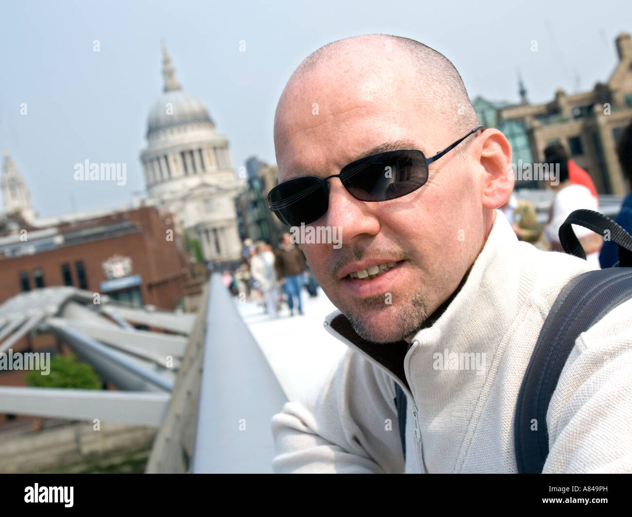 Man standing on the Millennium Bridge over the River Thames with St ...