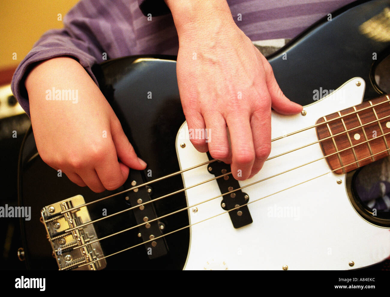 Teacher shows a boy how to play base during a lesson in music in school ...