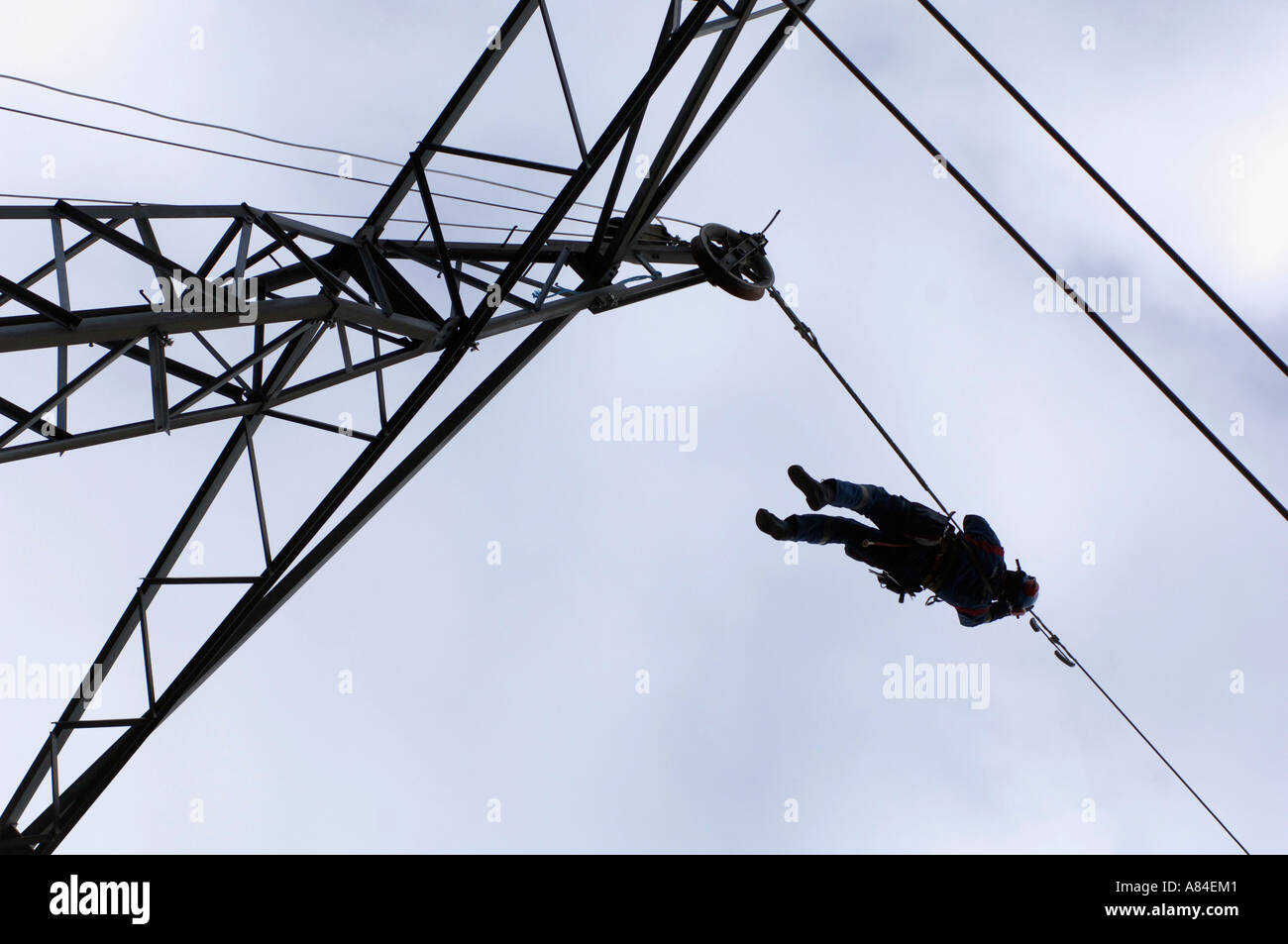 Worker changing the top wire on electric power transmission ...