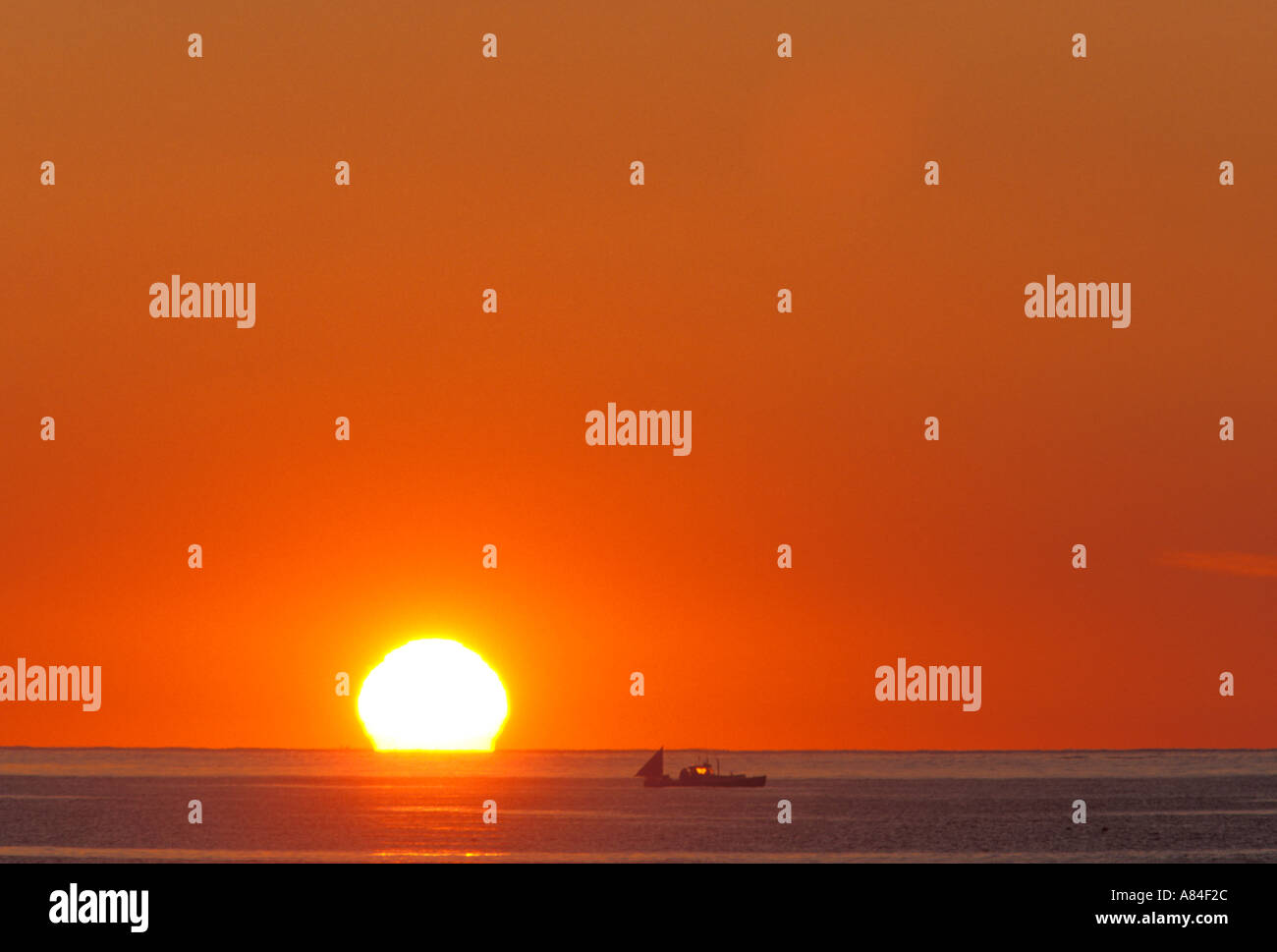 Fishing boat on ocean below rising sun off the coast of Maine Atlantic ...