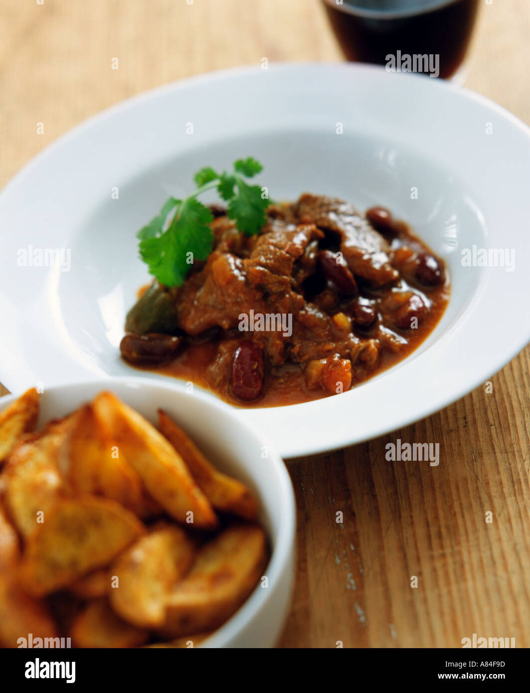 Beef casseroled with kidney beans served with roast potato chips wedges ...