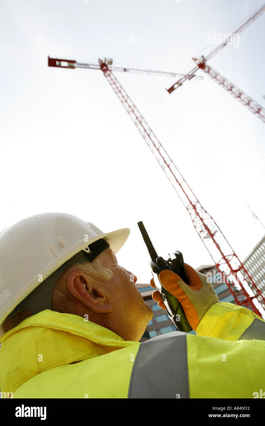 Construction of building workman in foreground Stock Photo - Alamy