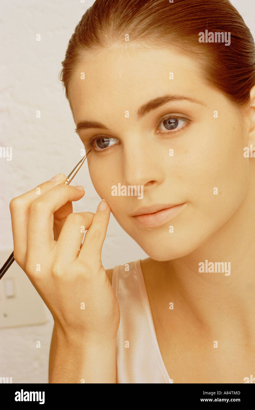 Studio portrait of young woman professional model applying makeup Stock ...