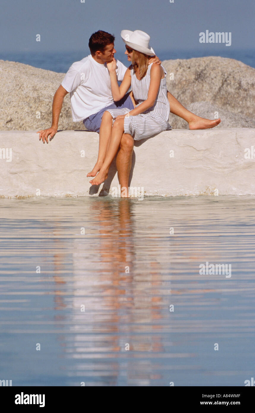 Two couples sitting by swimming pool hi-res stock photography and ...