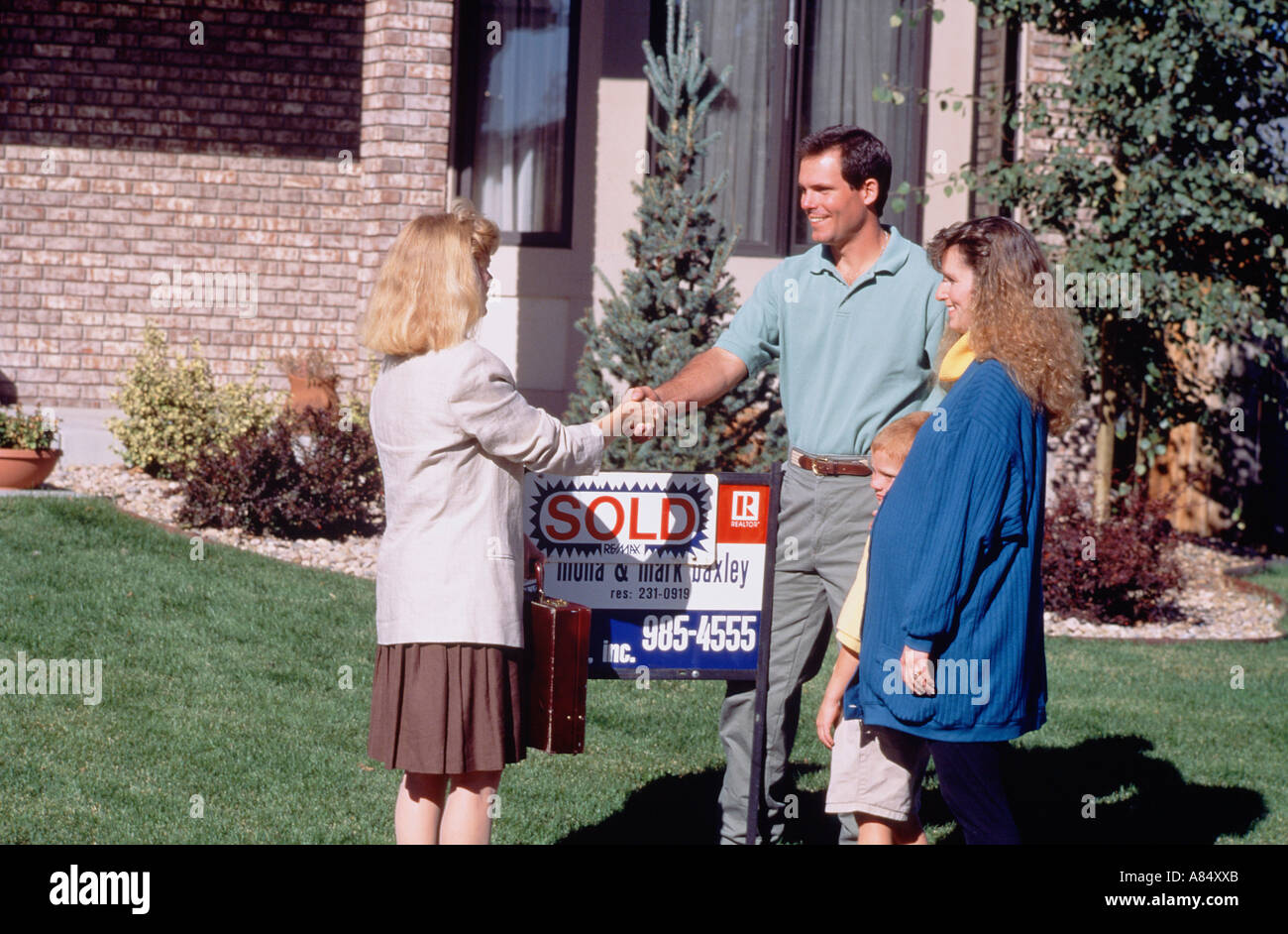 Real estate agent woman completing home sale to young family clients ...