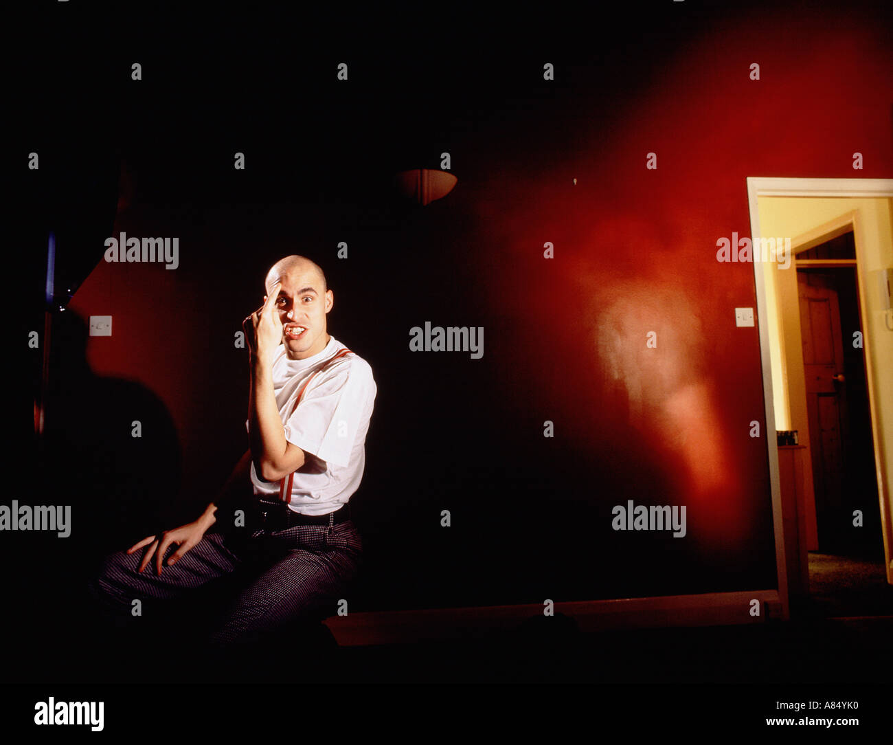 Angry young man sitting in a room Stock Photo - Alamy