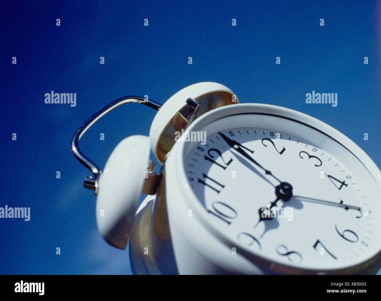 Concept image of white, traditional alarm clock against blue sky Stock ...