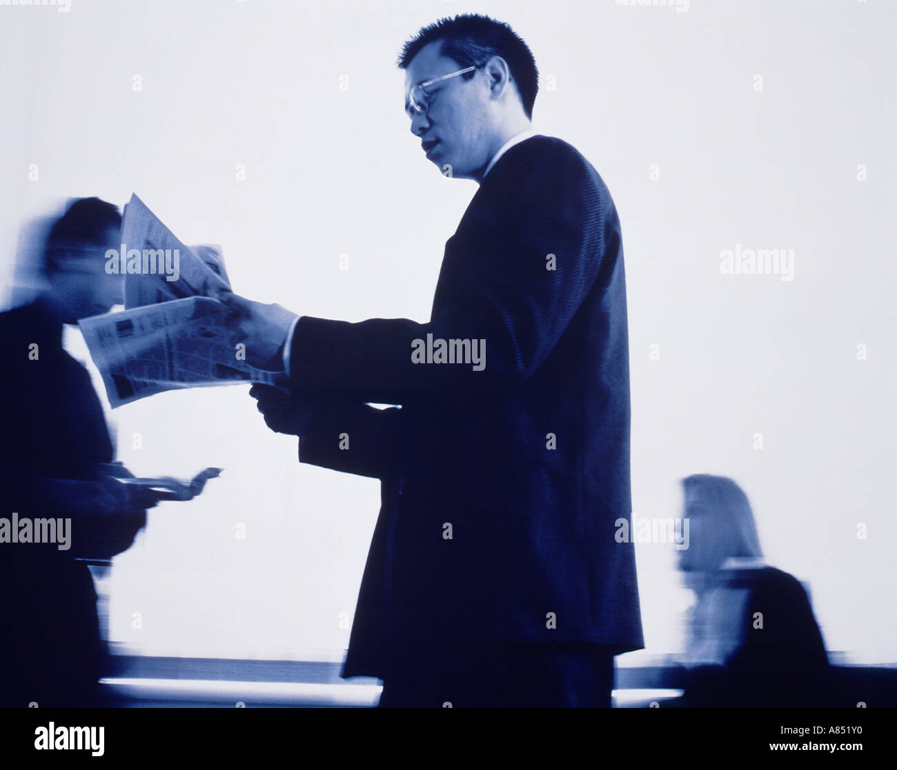 Indoor close-up side view of Chinese man reading newspaper Stock Photo ...