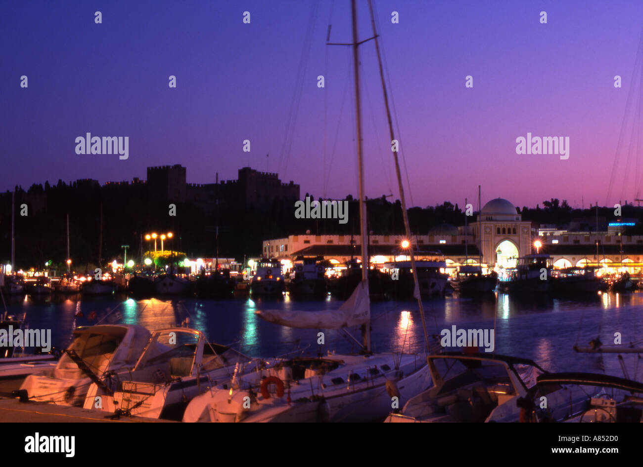 Greece Rhodes New Town Mandraki harbour at dusk showing the New Market ...