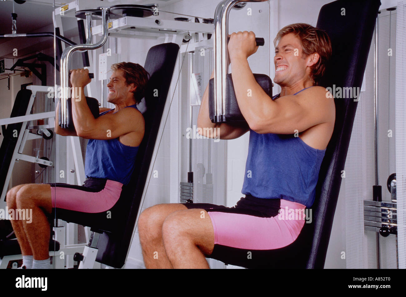 Young man exercising using gymnasium equipment Stock Photo - Alamy