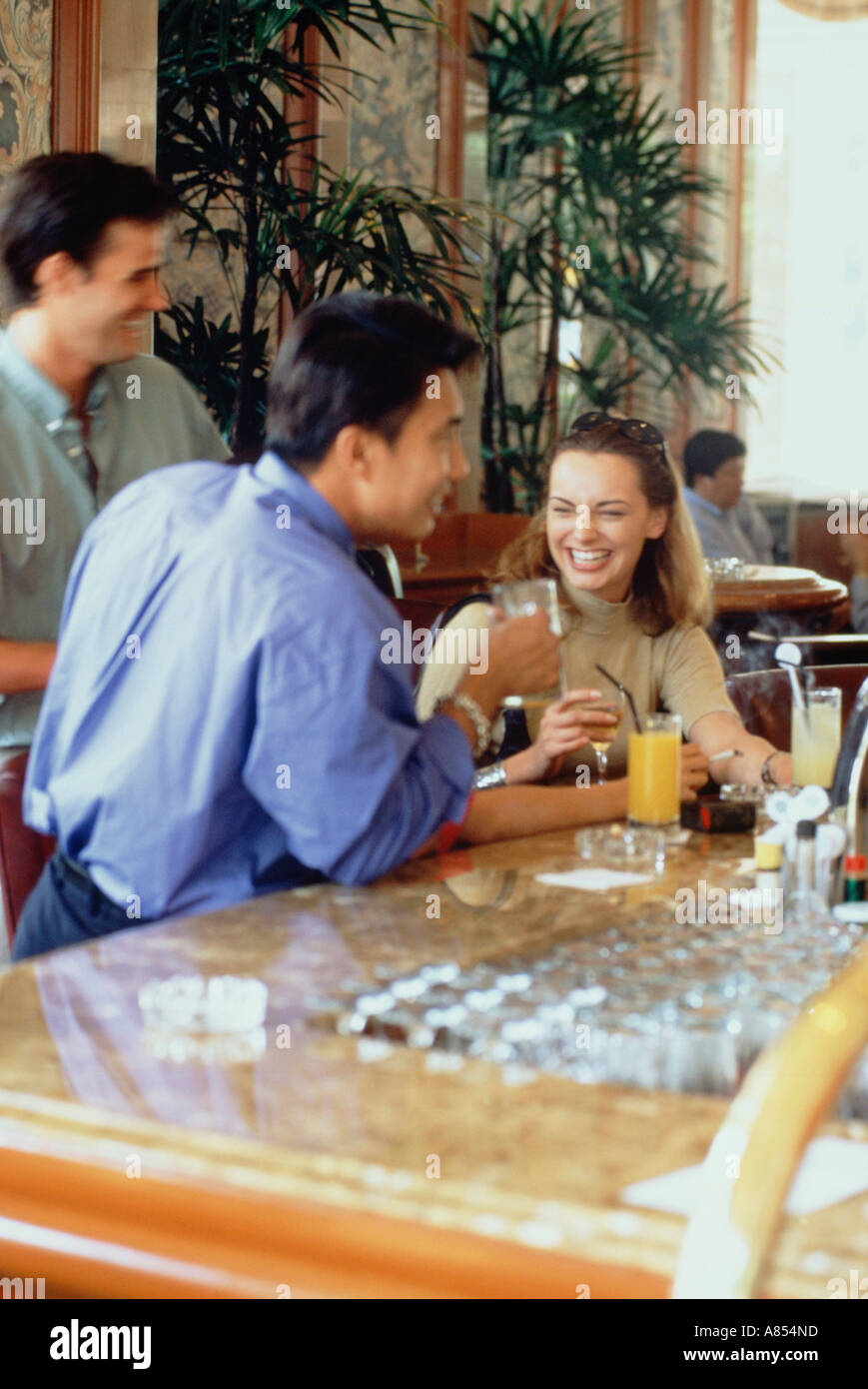 Three young people drinking in hotel cocktail bar Stock Photo - Alamy