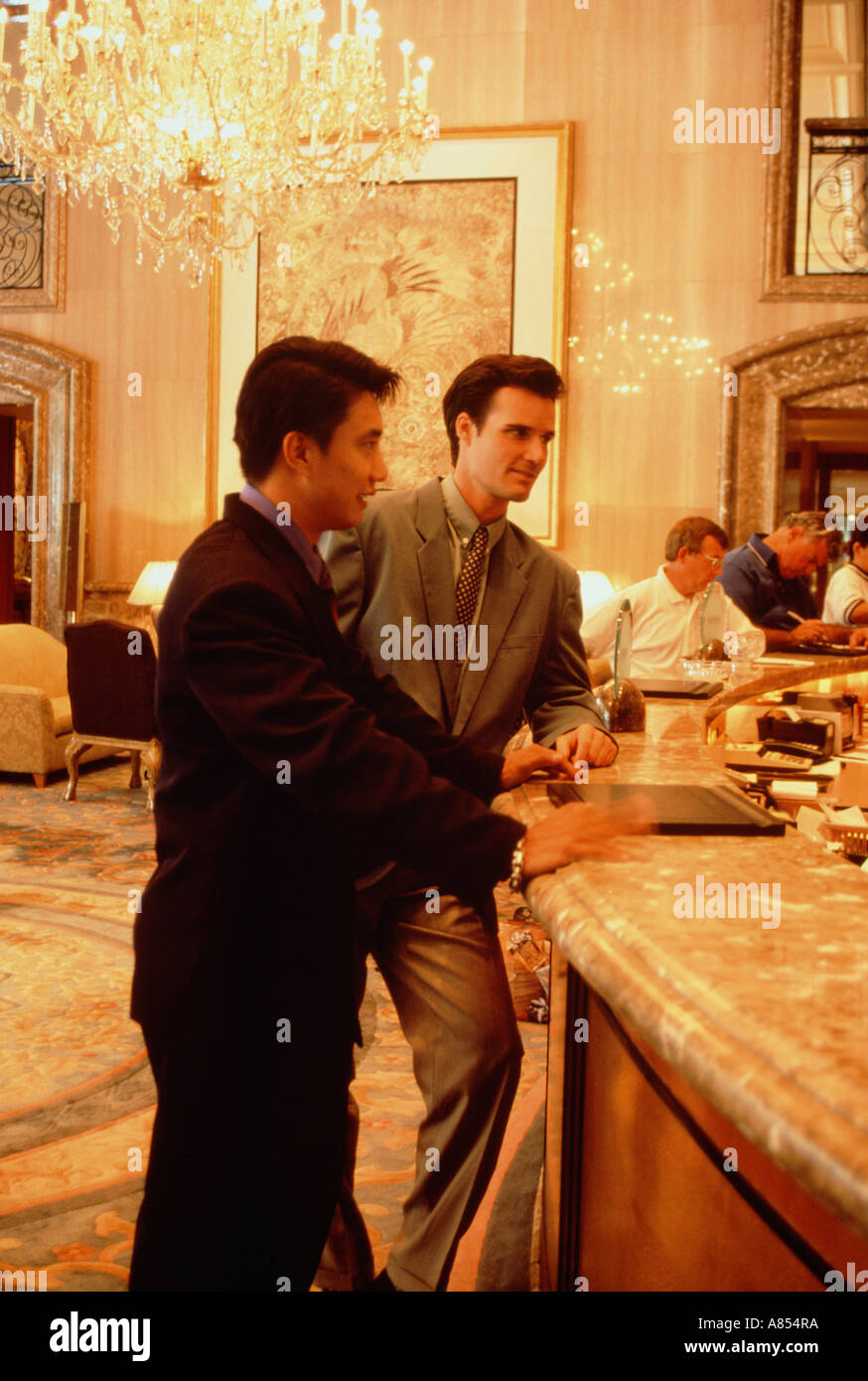Two men at hotel reception desk Stock Photo - Alamy