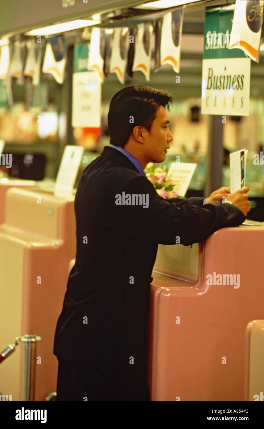 Young man executive at airline check in desk Stock Photo - Alamy